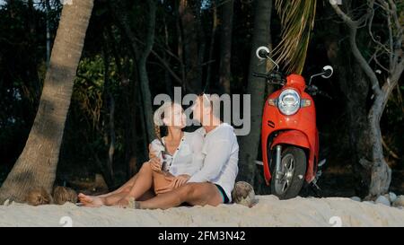 Scooter road trip. Lovely couple on red motorbike in white clothes on ...