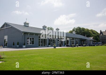 Barn at Barra Castle wedding venue from a distance with the fields ...