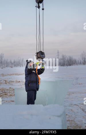 The slinger puts on a tape sling on the hook of a truck crane Stock ...