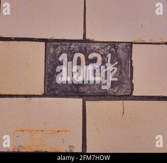 House Number 102 sign on wall painted red Stock Photo - Alamy