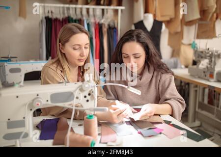 Designers inspecting sample fabric in atelier Stock Photo - Alamy