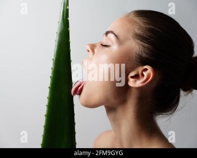 woman with clean skin licks aloe leaf closeup portrait Stock Photo - Alamy