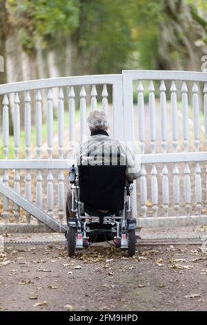 Wheelchair users in front of a locked entrance gate Stock Photo - Alamy