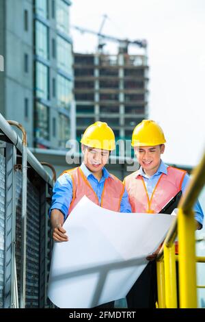 Asian Indonesian construction workers on building site Stock Photo - Alamy