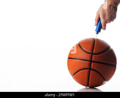Basketball inflated with a hand pump on a white background Stock Photo ...