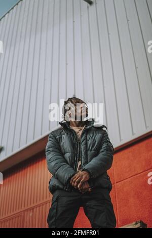 Serious handsome man posing and looking at camera isolated over yellow ...