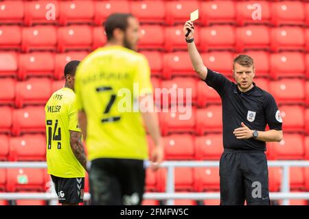 Referee Samuel Barrott shows a yellow card to Bayern's Hiroki Ito ...