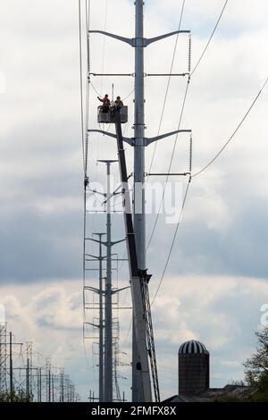 Electricity utility workers maintain power distribution lines in ...