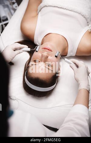 Woman beauty face with galvanic gel, female patient receives galvanic ...