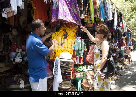 Young hispanic shopkeeper man smiling happy holding clipboard working ...