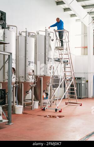 Unrecognizable female in casual cotton dress carrying stylish shoes of ...