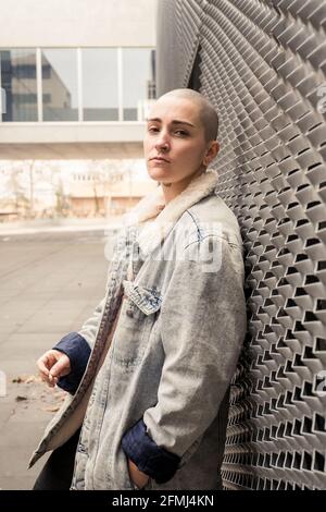 Side view of queer person in crop top with snakeskin print and jeans ...