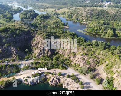 A drone shot of a river flowing in a green forest Stock Photo - Alamy
