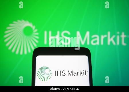 IHS Markit logo seen on the smartphone placed on the screen with the S ...