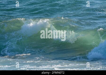 waves crashing on jagged black rocks Stock Photo - Alamy