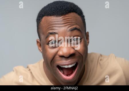 Photo of positive man toothy smile hold use telephone empty space ...