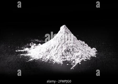 Titanium dioxide (TiO2) powder for cosmetics, isolated black background ...