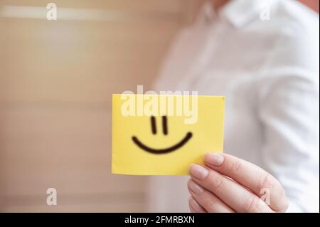 Hand of client show a feedback with smiley face. Service rating ...