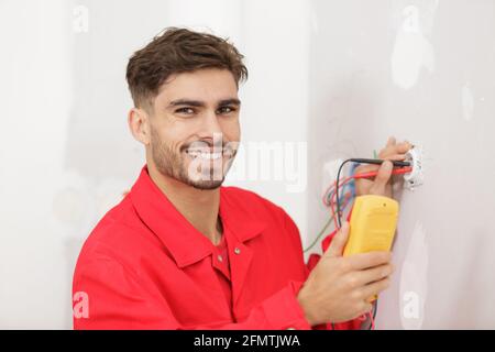 happy electrician checking socket voltage Stock Photo - Alamy