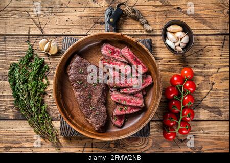 Grilled sliced top blade or denver beef meat steak in a wooden plate ...
