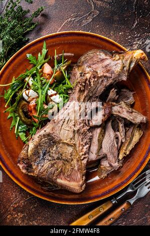 Grilled goat or lamb mutton shoulder meat in a rustic plate with salad ...