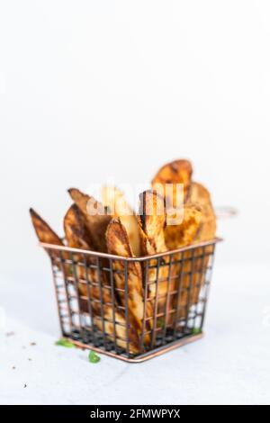 Freshly baked potato wedges with spices in a wire basket Stock Photo ...