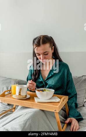 Emotional young woman eating tasty banana on color background Stock ...