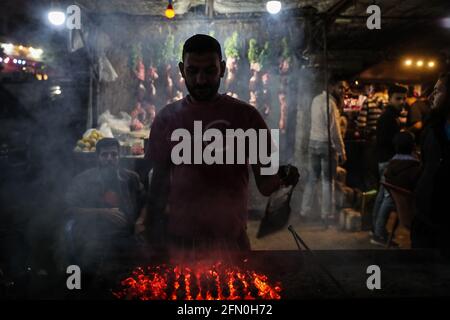 Idlib, Syria. 13th May, 2021. A vendor sells food in a street market in ...