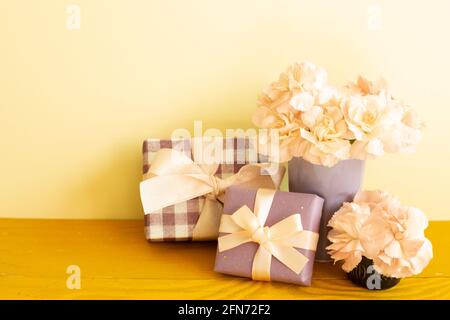 Gift boxes with carnation flowers on wooden table. blue background ...