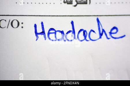 The word headache that is handwritten by a physician on a hospital ...