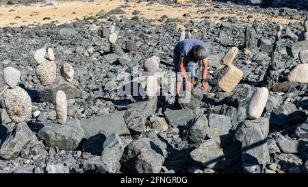 Pebble sculptures on St Ives beach Cornwall. Pebble sculptor at work ...