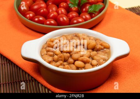 ceramic pot with carioca beans cooked (feijoada) on table with mat and ...