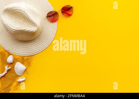 Top view of flip flops, straw hat and cherries on yellow background ...