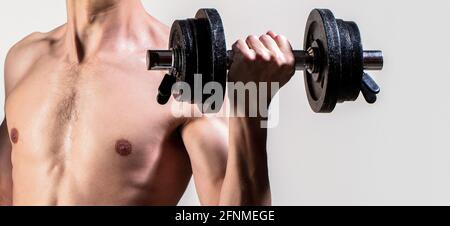 Skinny guy hold dumbbells up in hands. A thin man in sports with ...