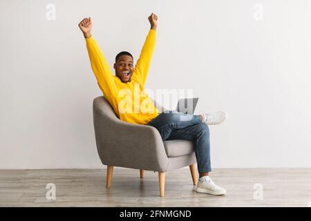 Joyful Black Guy Using Laptop Gesturing Yes Holding Paper Indoors Stock ...