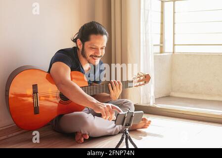 young man learning how to play guitar on computer Stock Photo - Alamy