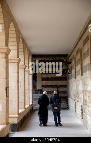 Lay man and benedictine monk in San Pietro di Sorres basilica cloister ...