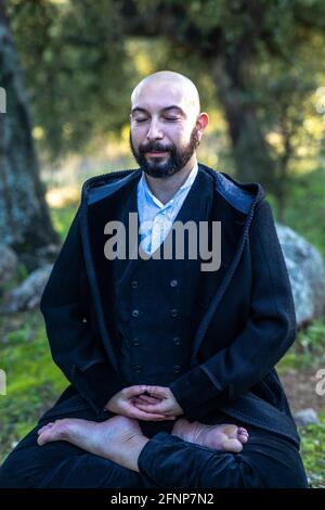 Sardinian man sitting and meditating in Biru 'E Concas megalitic ...