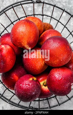 Fresh red nectarines in a steel basket. Gray background. Top view Stock ...