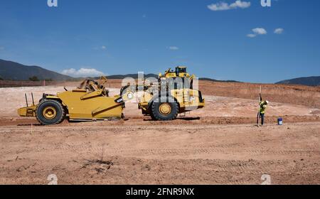 A heavy-equipment operator uses a Caterpillar 120H Motor Grader to move ...