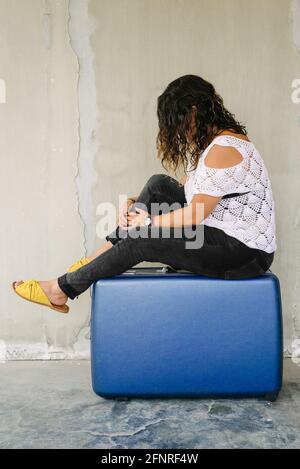 Woman traveler with suitcase in sweater yawn, stretching and raised ...