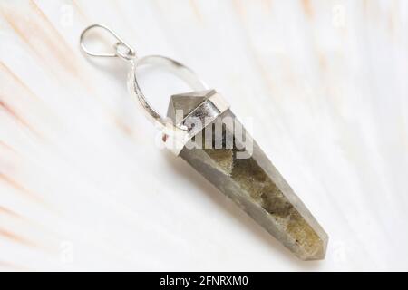 Metal frame mineral stone pendant on white shell background Stock Photo ...