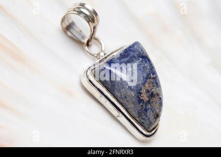 Metal frame mineral stone pendant on white shell background Stock Photo ...