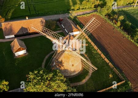 Traditional Hungarian windmill near Hodmezovasarhely. Canola field at ...