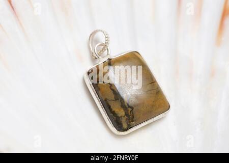 Metal frame mineral stone pendant on white shell background Stock Photo ...