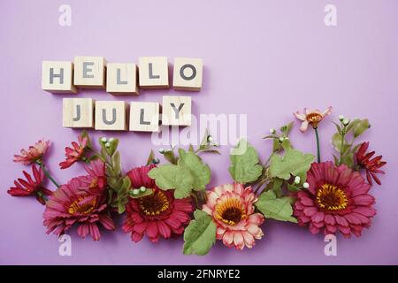 Hello July alphabet letters with pink flower decoration on marble ...