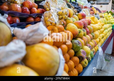 Colorful fruit stand with papayas, tangerines, apples, mangoes and more ...