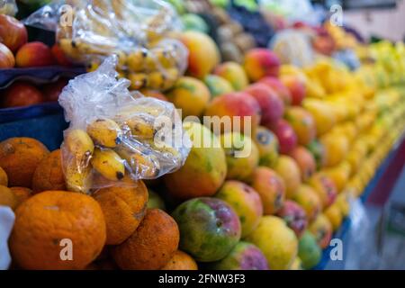 Colorful fruit stand with mangoes, small bananas, and more Stock Photo ...