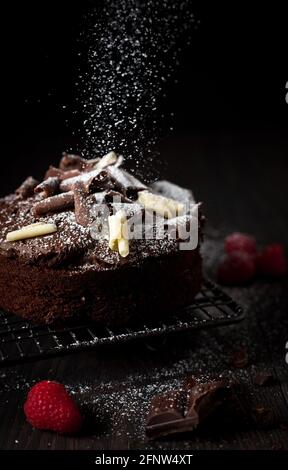 Icing sugar falling onto chocolate gateau Stock Photo - Alamy