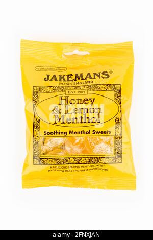 A packet of Jakemans honey and lemon menthol sweets shot on a white ...